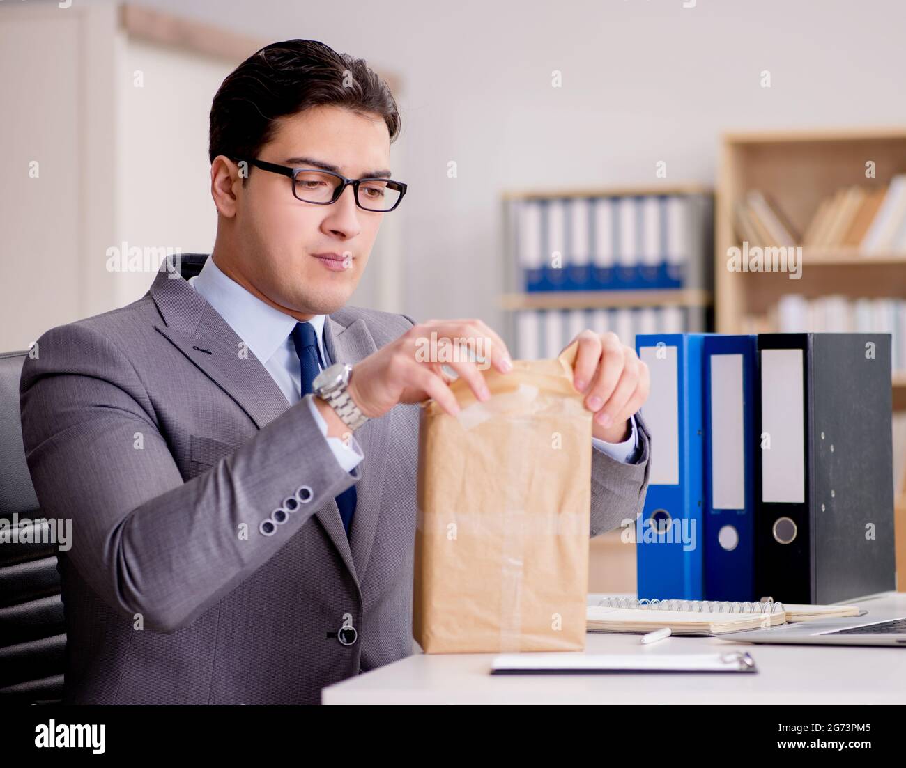 The businessman receiving parcel in office Stock Photo - Alamy