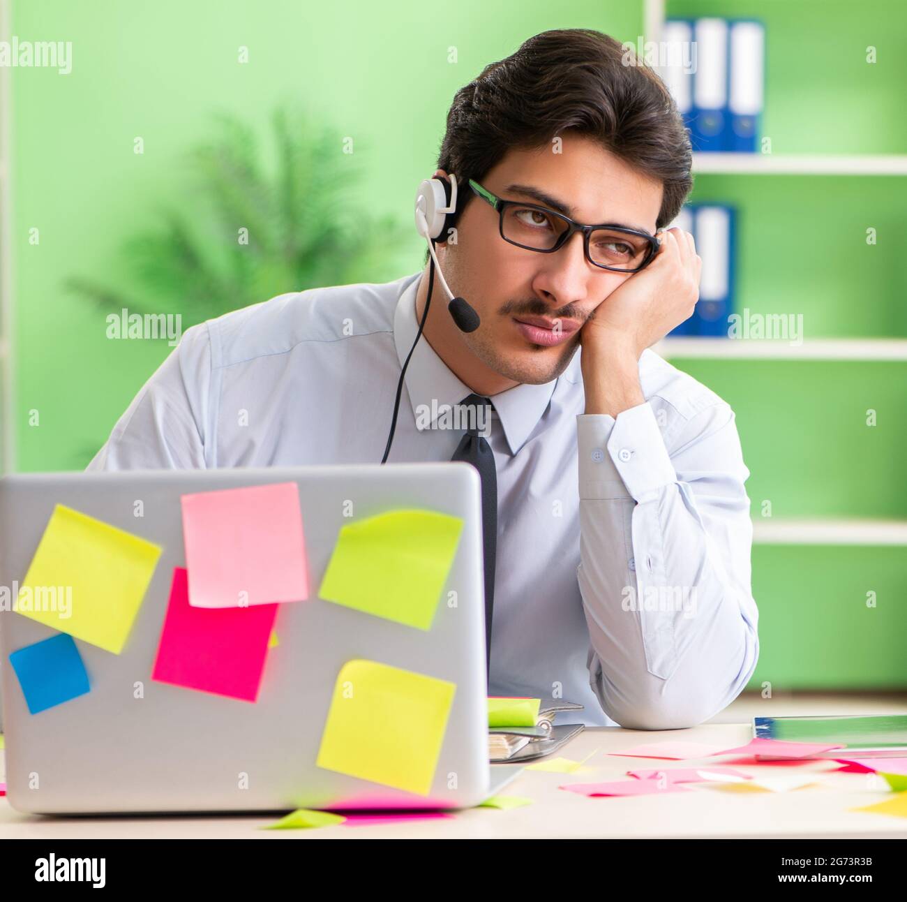 Young help desk operator working in office with many conflicting ...