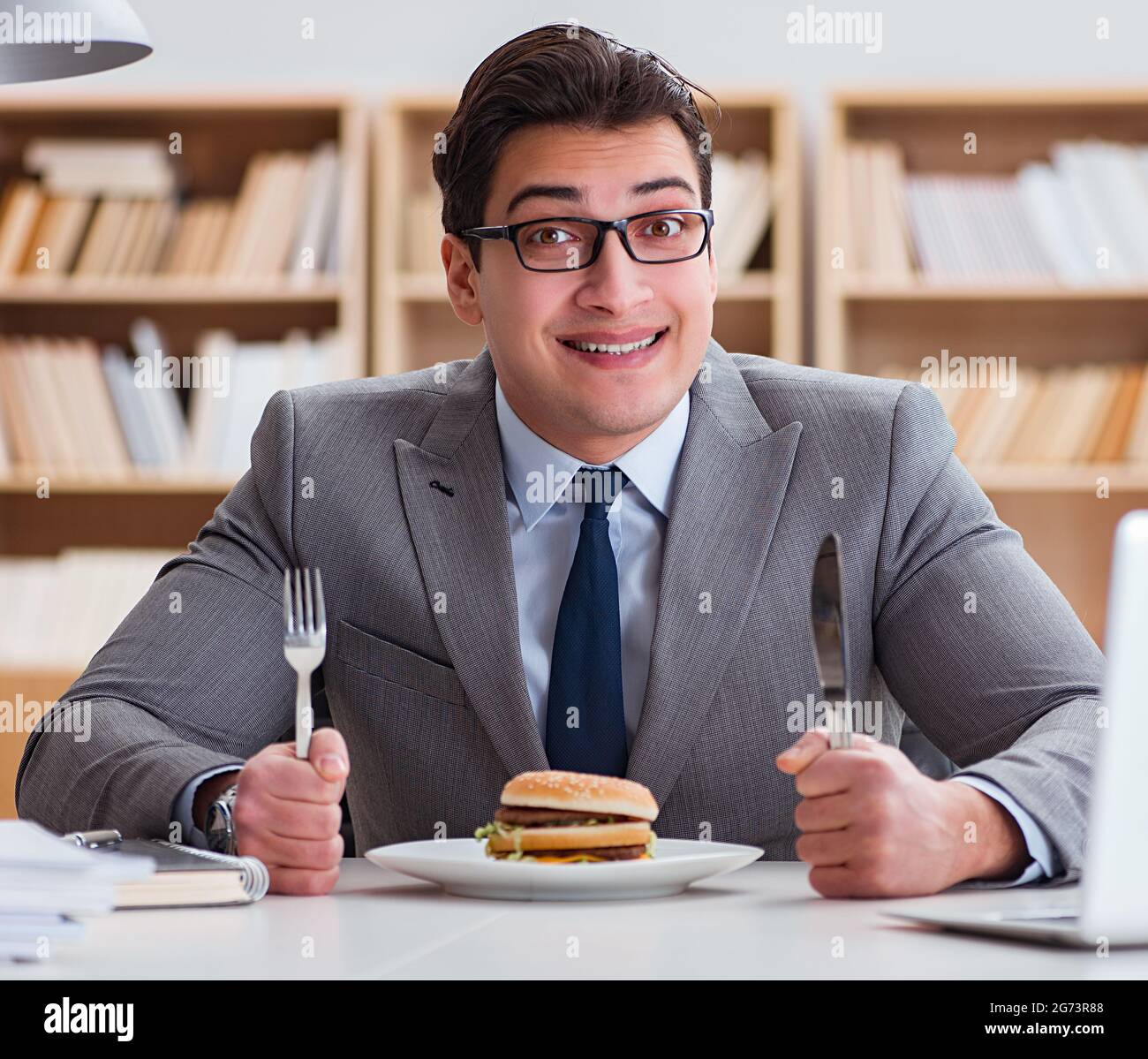 The hungry funny businessman eating junk food sandwich Stock Photo - Alamy