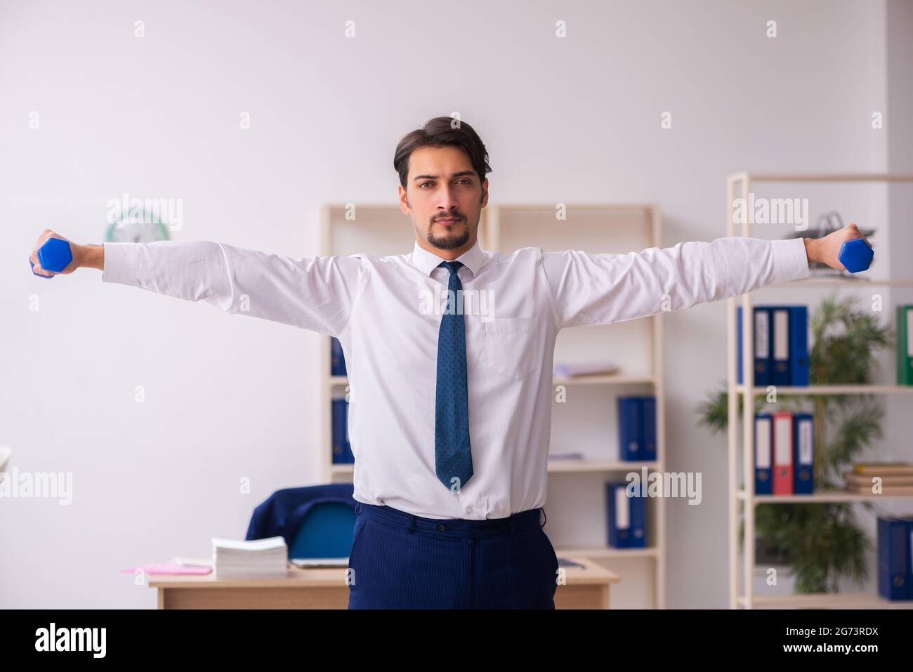 Young businessman employee doing sport exercises during break Stock ...