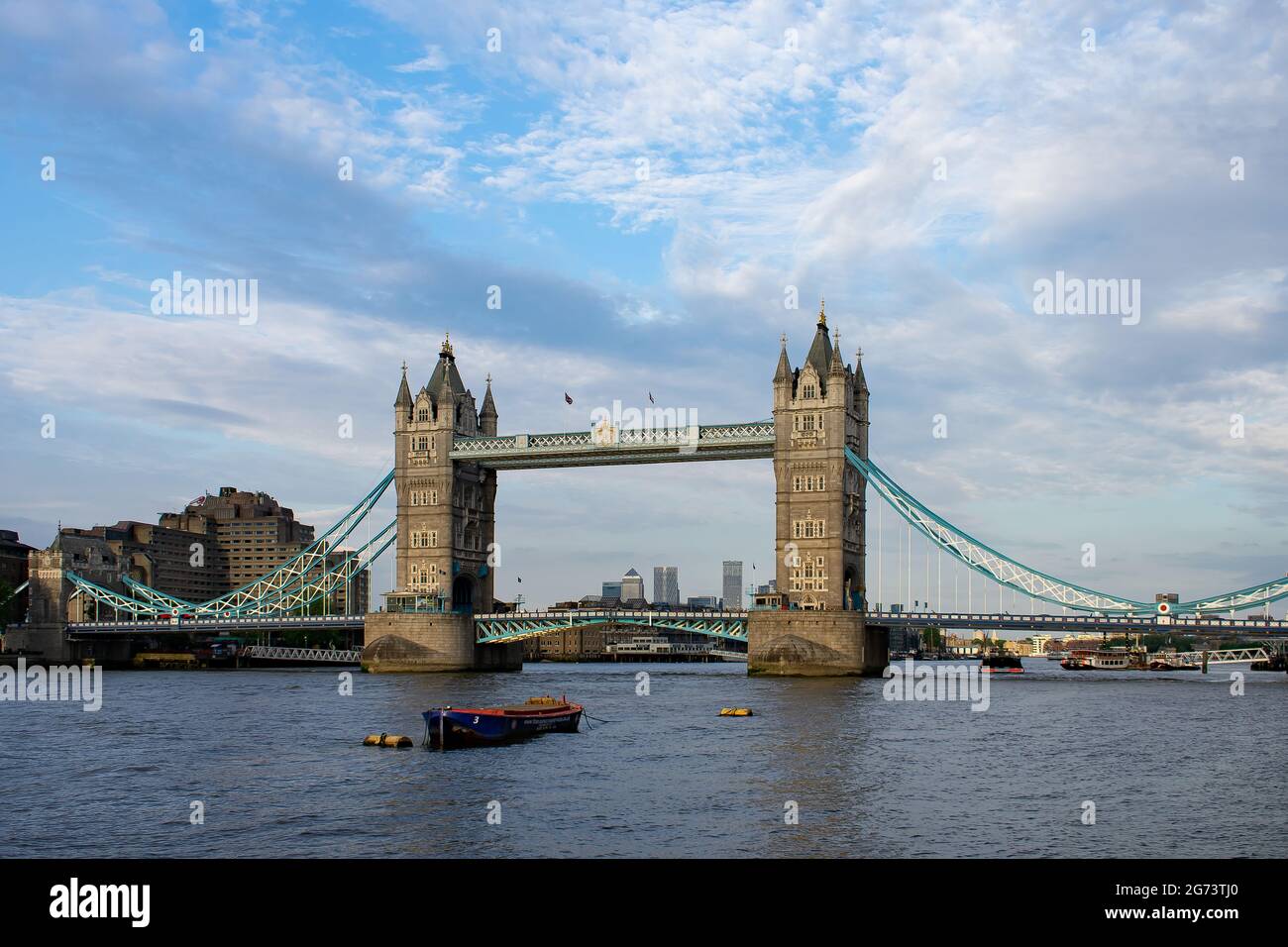 A small boat floats on the River Thames in front of the neo gothic ...