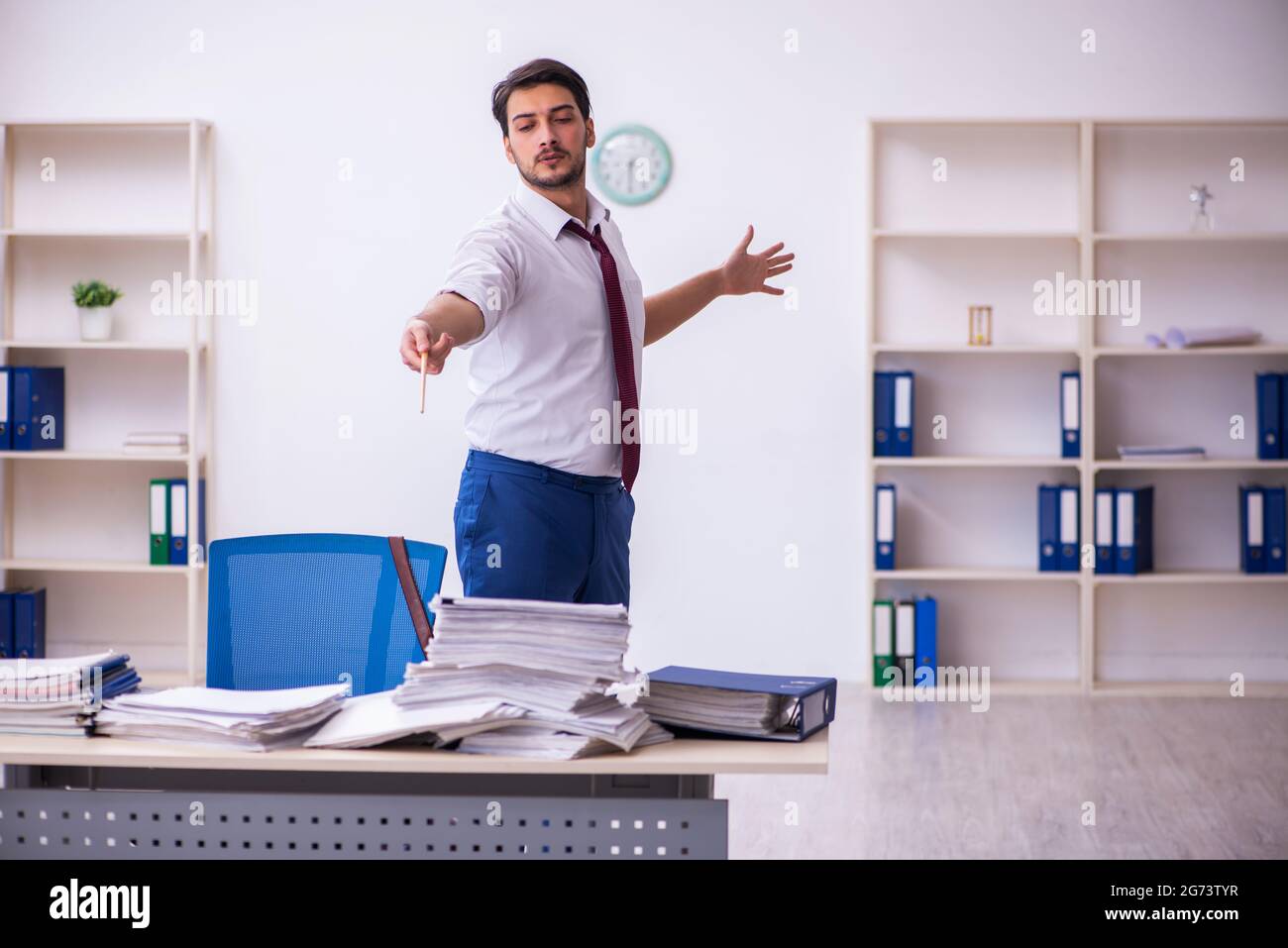 Funny young employee magician and too much work in the office Stock ...