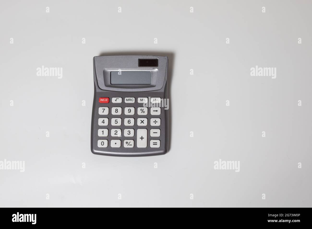 A plastic calculator on a white surface from above Stock Photo - Alamy