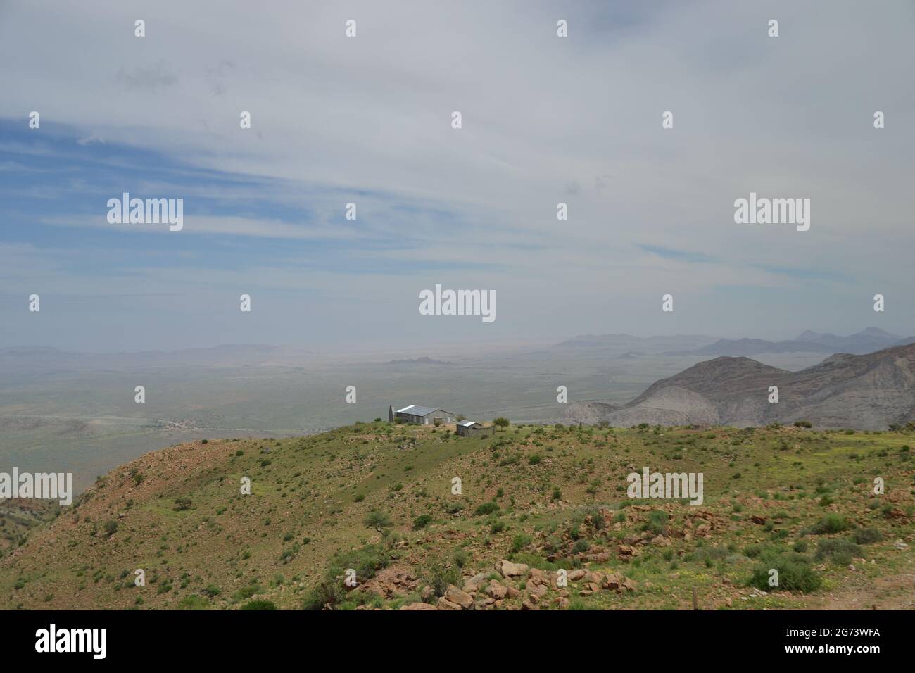 A tranquil scenery of a hut on the edge of a mountain on a misty day in ...