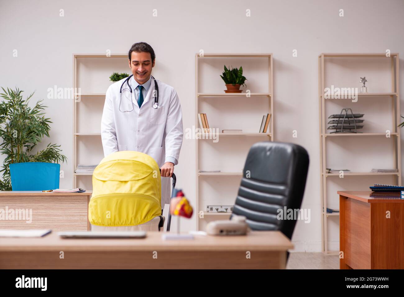 Young male doctor looking after new born at the hospital Stock Photo ...