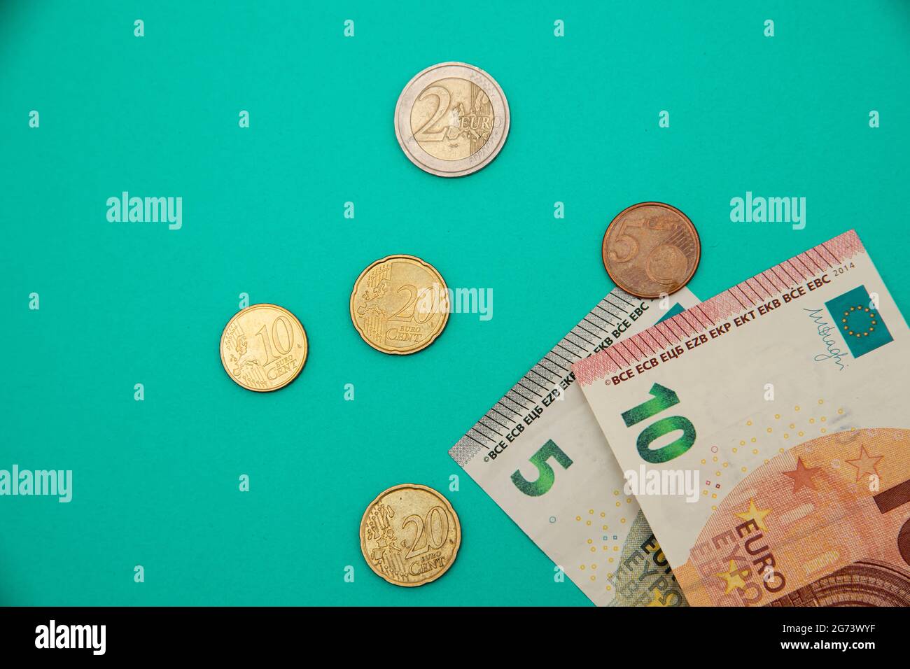 A top view of five and ten euro banknotes and coins on the down right ...