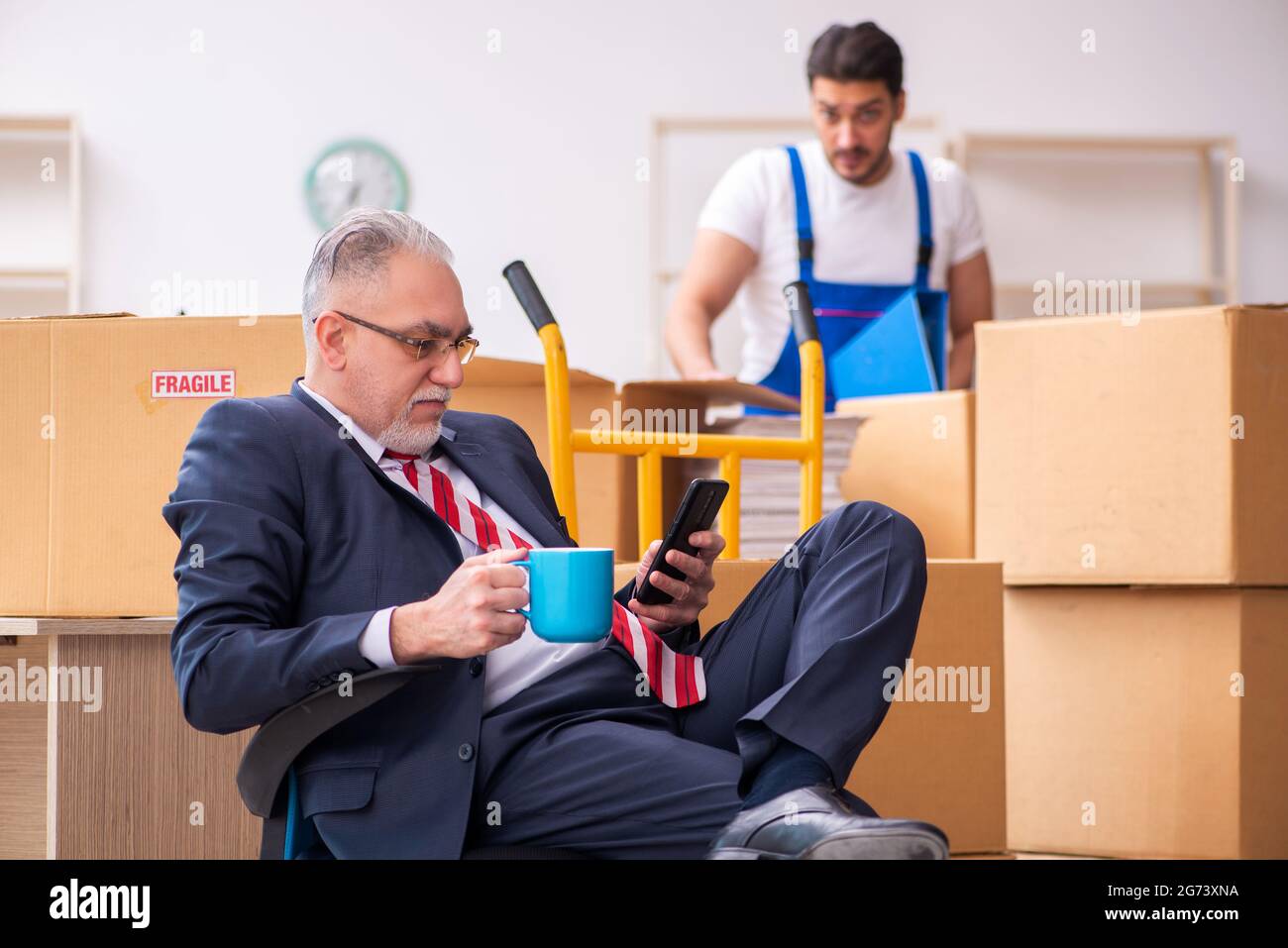Old male employer and young contractor in relocation concept Stock ...