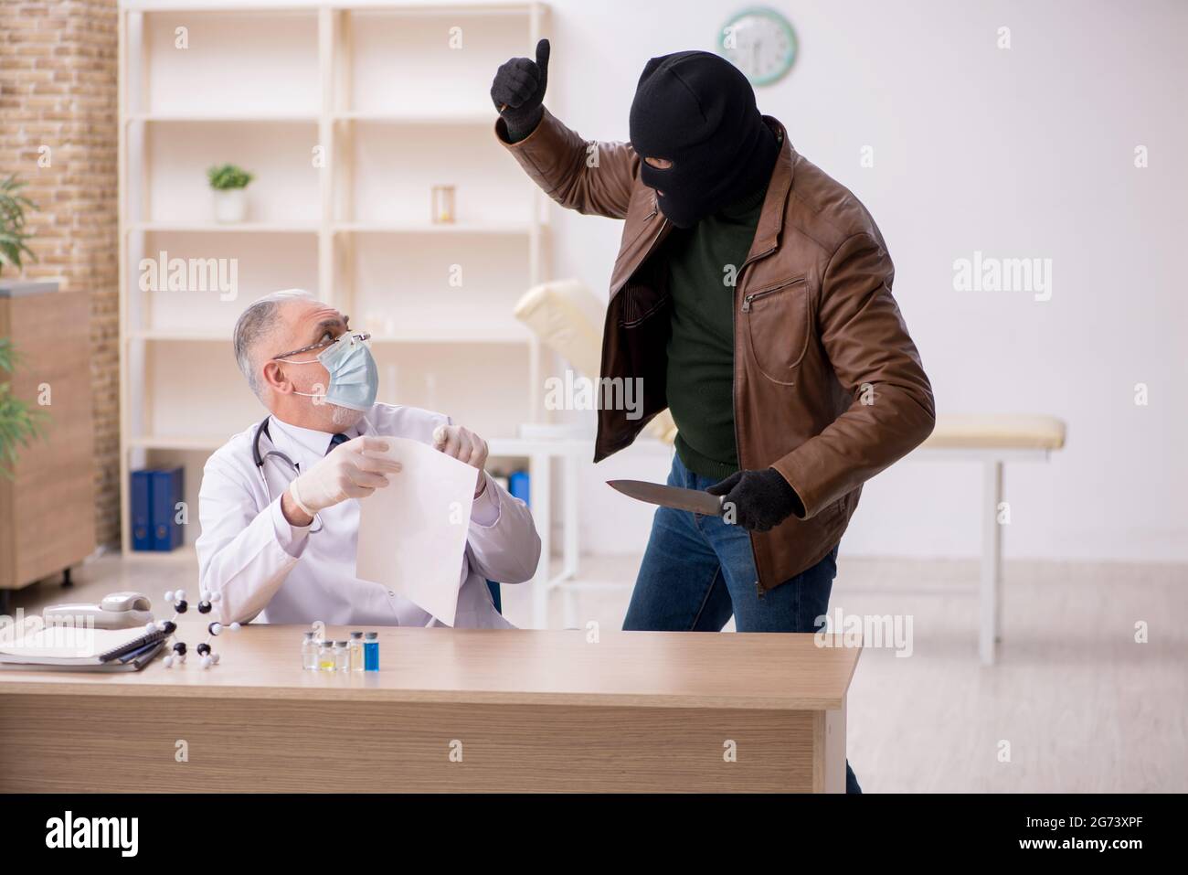 Burglar in balaclava stealing vaccine from old doctor Stock Photo - Alamy