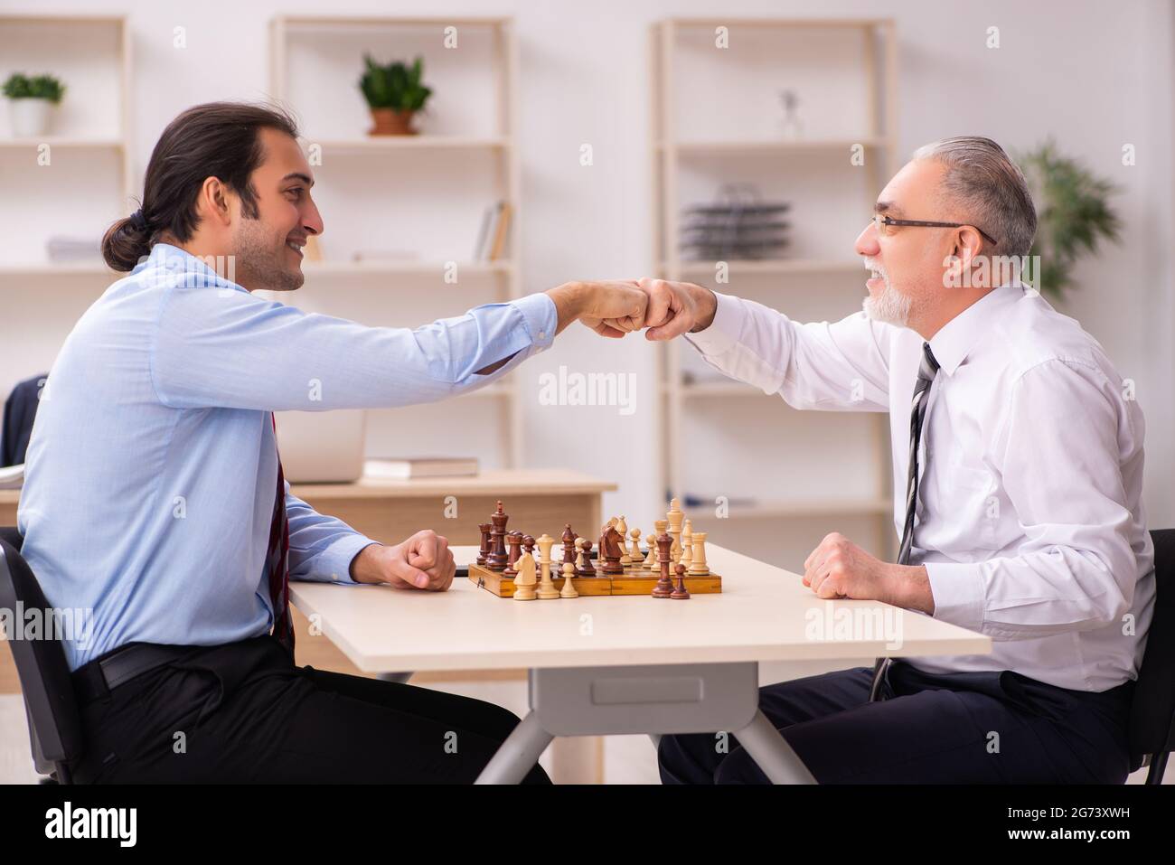 Two male employees playing chess at workplace Stock Photo - Alamy