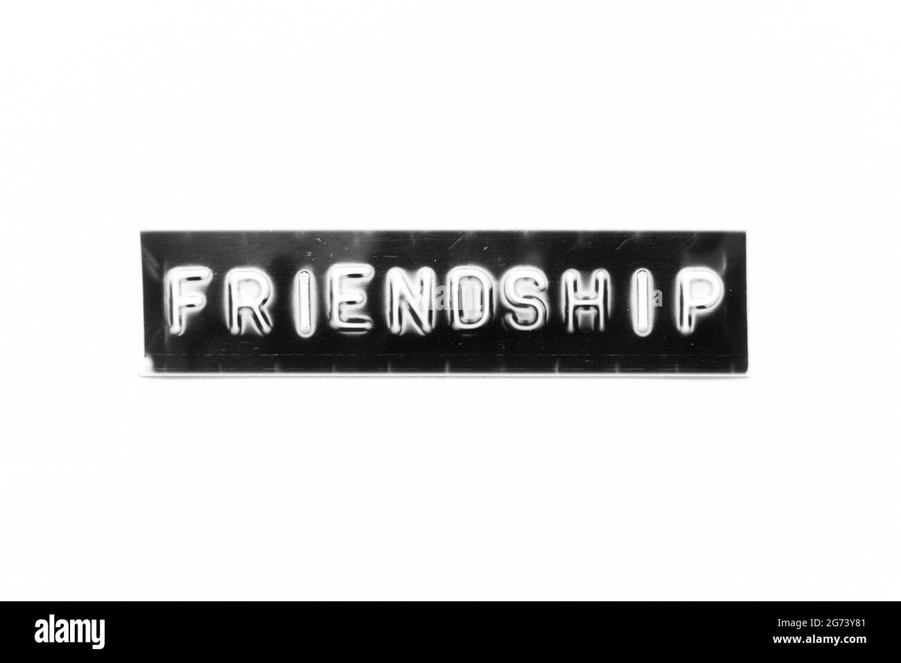 Embossed letter with word friendship in black banner on white paper ...