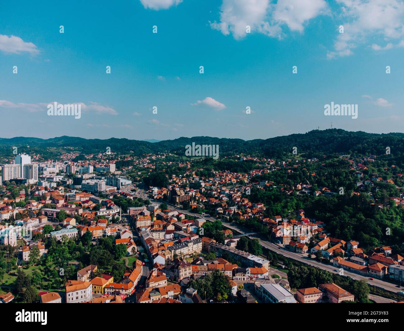 An aerial shot of the cityscape of Tuzla, Bosnia, under the blue sky ...