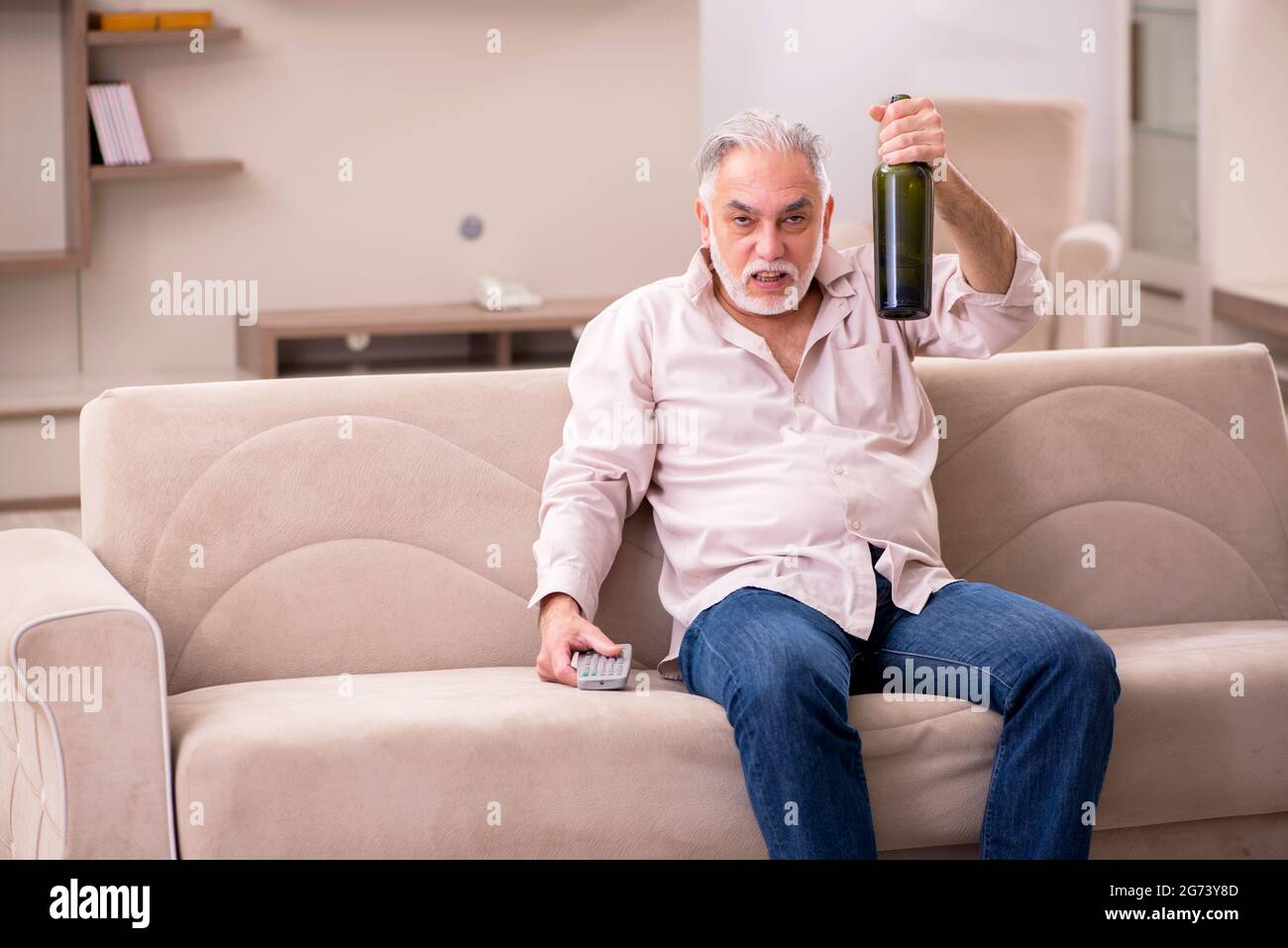 Aged man drinking alcohol at home Stock Photo - Alamy