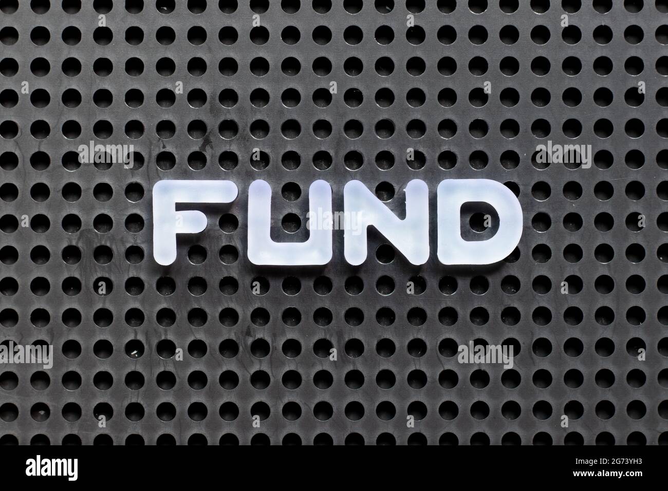 White color letter in word fund on black pegboard background Stock ...