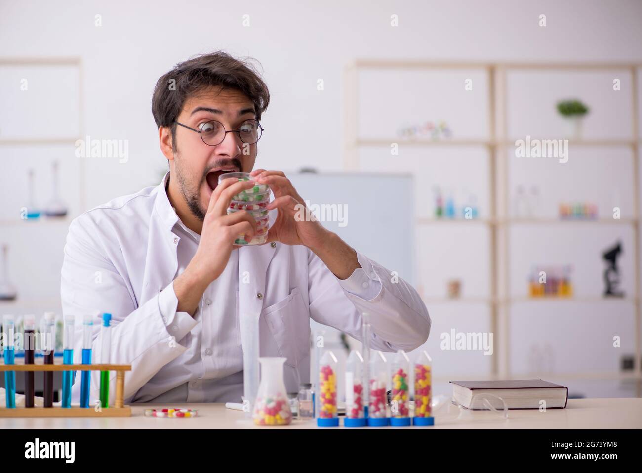 Young chemist in drugs synthesis concept Stock Photo - Alamy