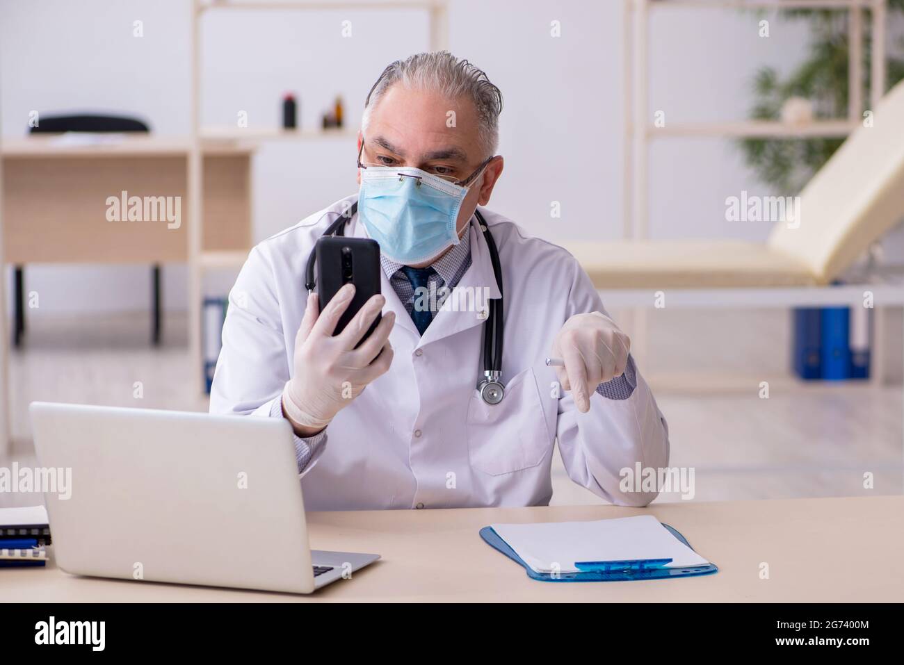 Old doctor working in the clinic Stock Photo - Alamy