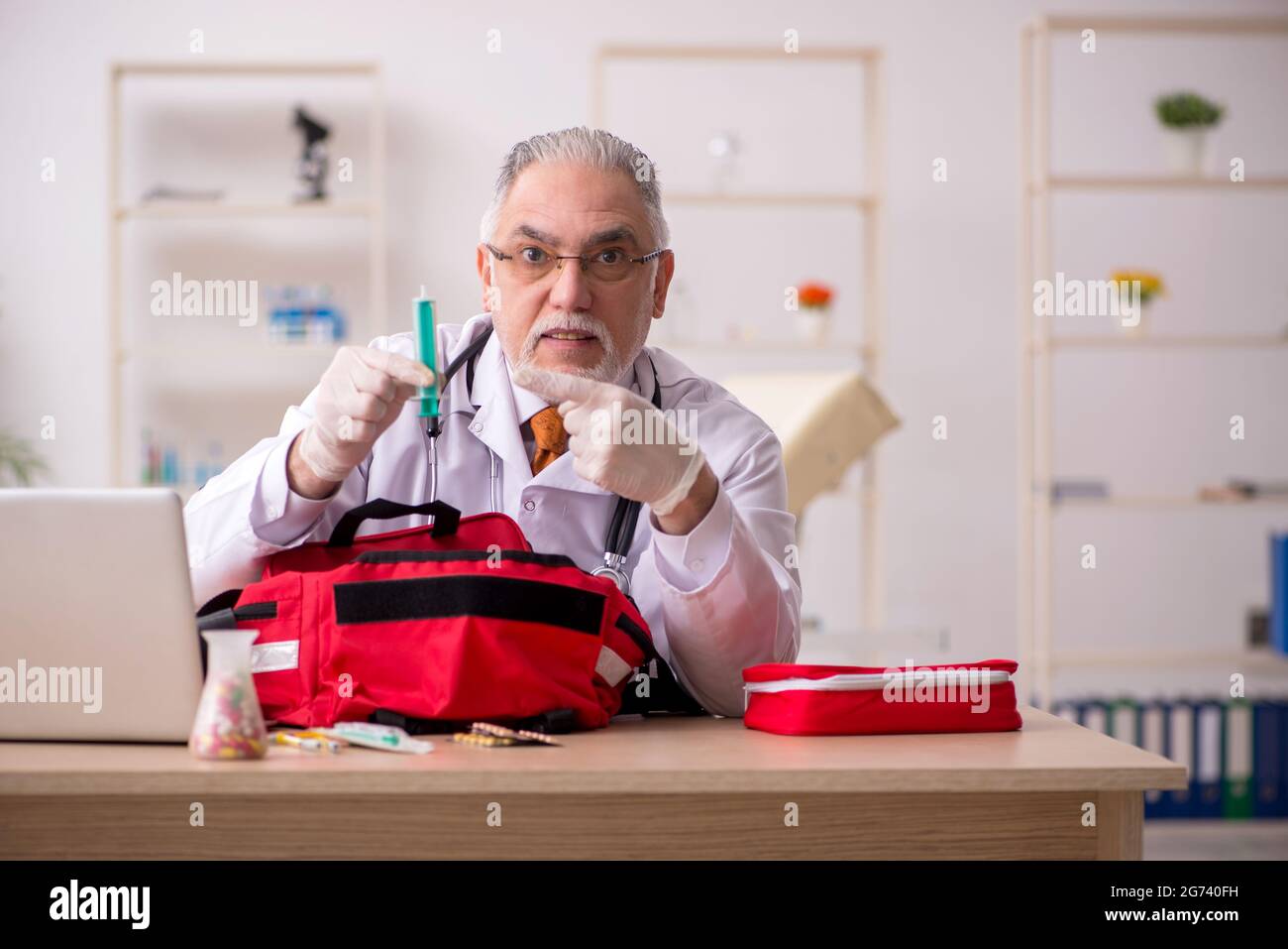 Old doctor in first aid concept Stock Photo - Alamy