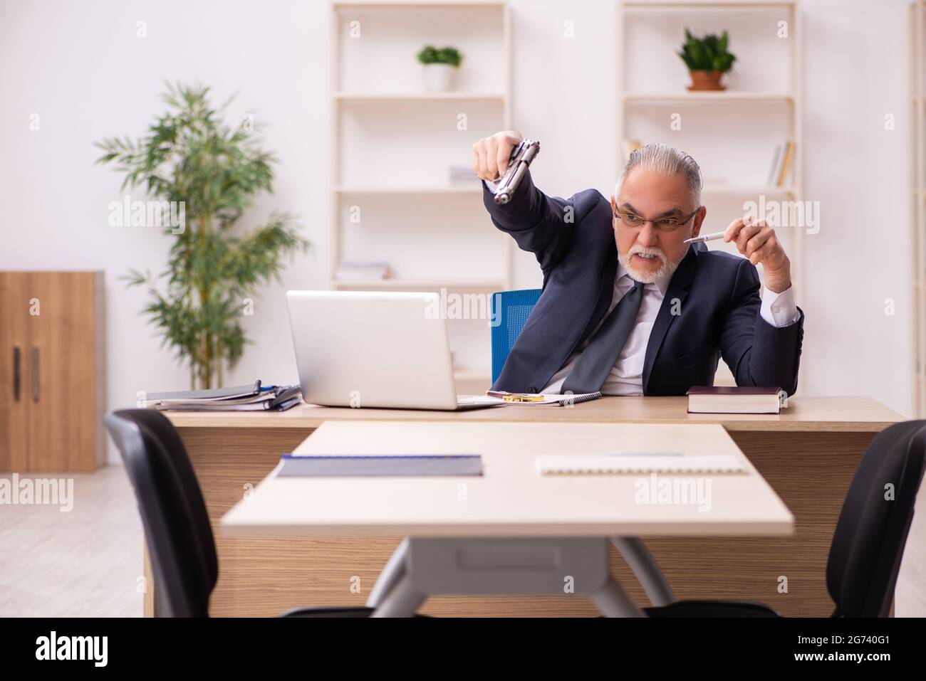 Angry businessman aiming gun hi-res stock photography and images - Alamy