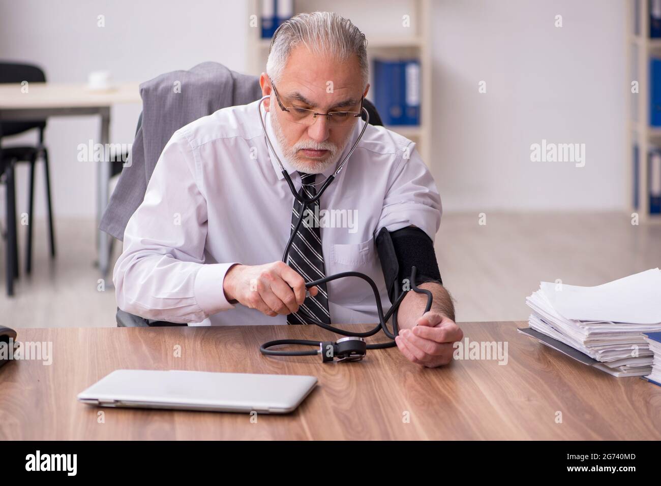 Aged male employee feeling bad in the office Stock Photo - Alamy