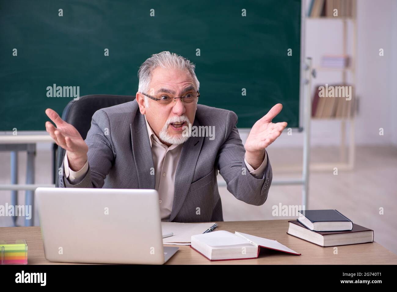 Old teacher in front of blackboard Stock Photo - Alamy