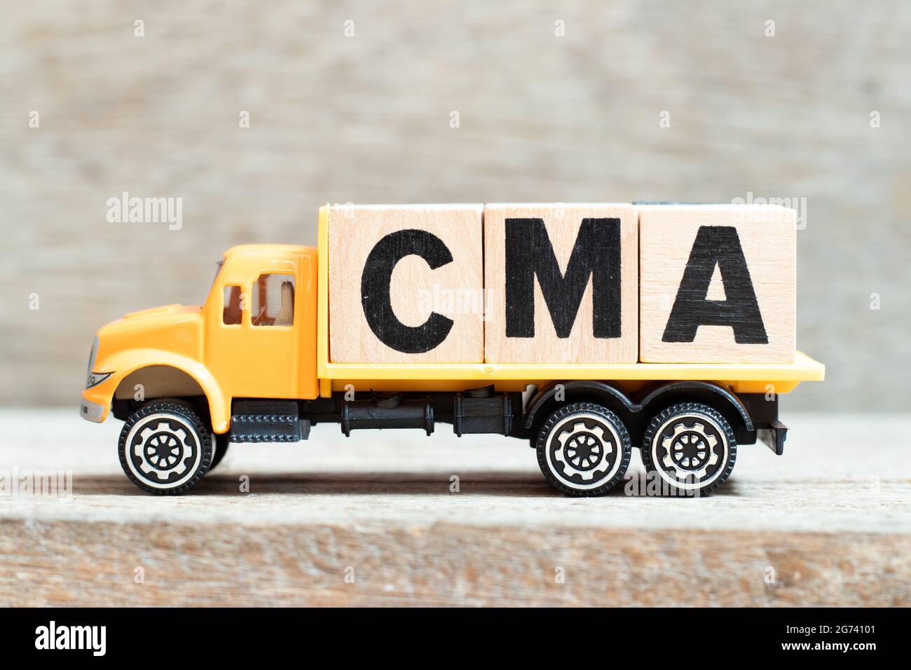 Toy truck hold alphabet letter block in word CMA (Abbreviation of ...