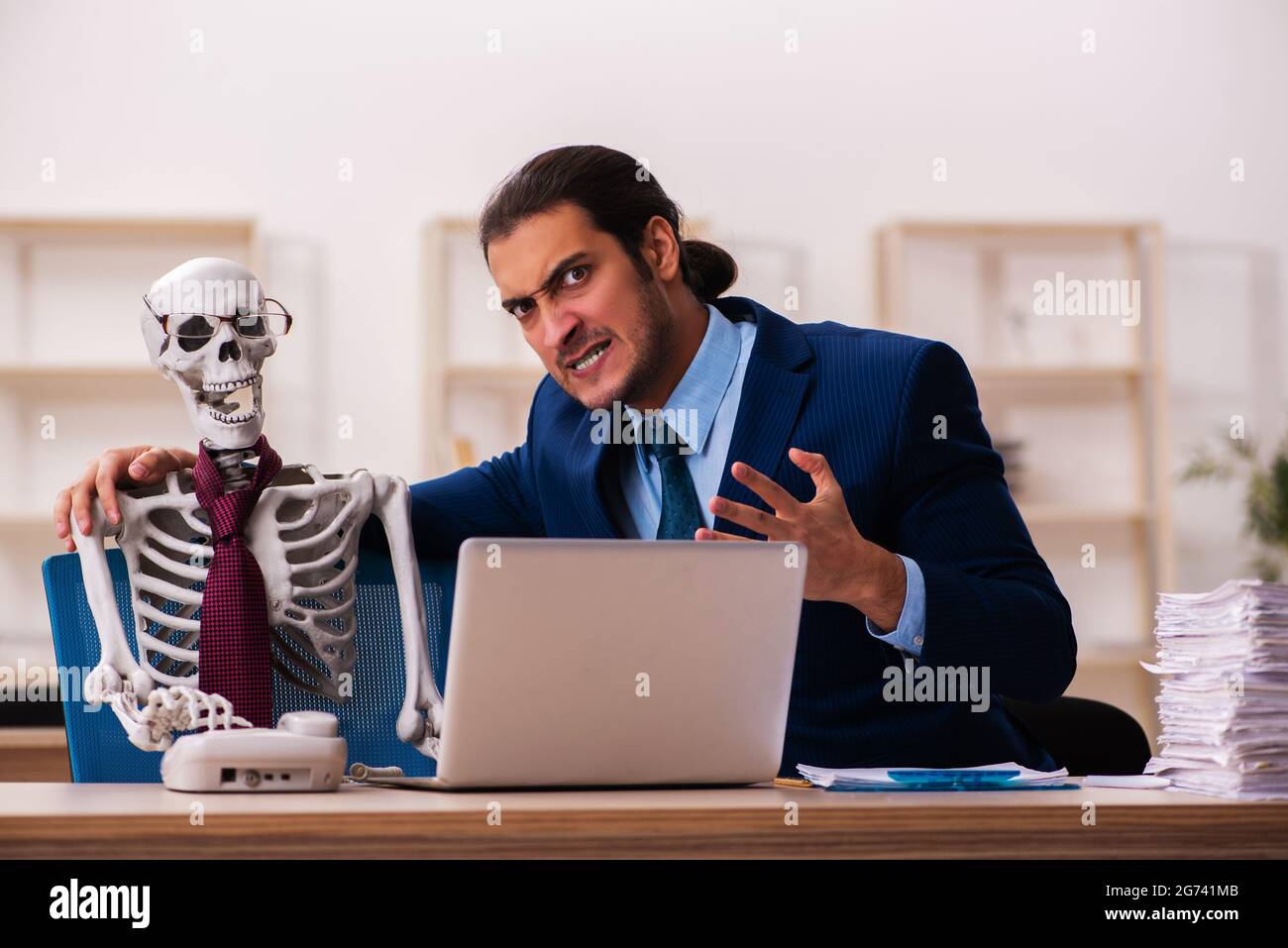 Dead employee working in the office in funny concept Stock Photo - Alamy