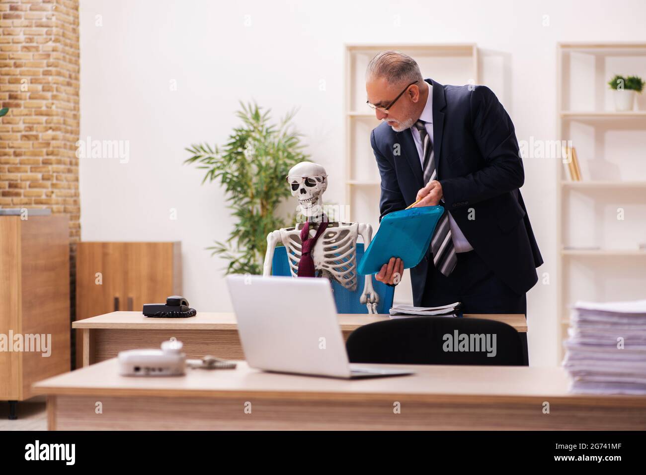 Dead employee working in the office in funny concept Stock Photo - Alamy