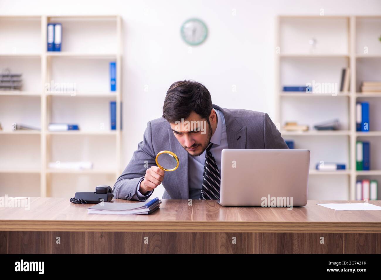 Young male auditor employee working in the office Stock Photo - Alamy