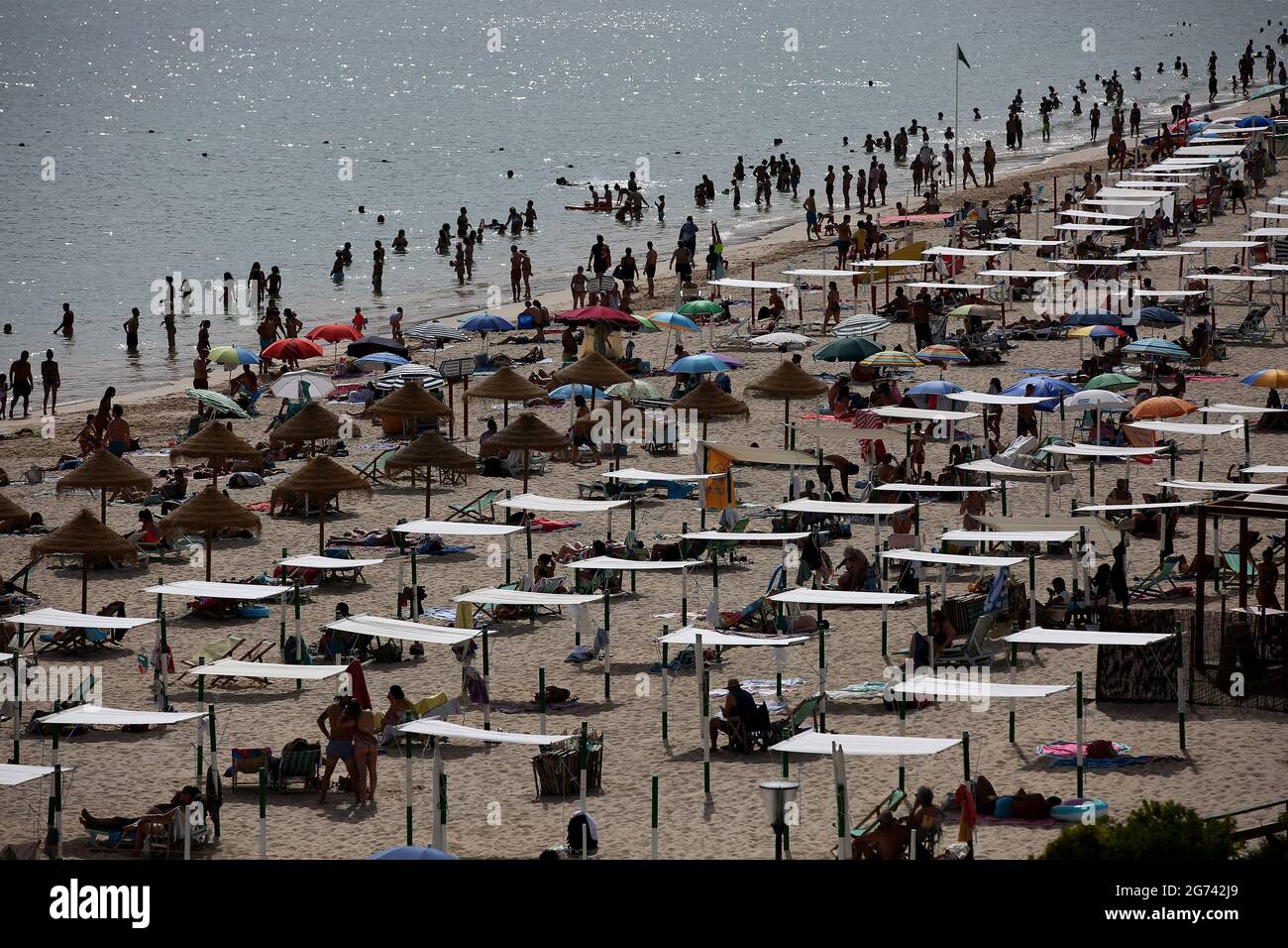 Lisbon, Portugal. 10th July, 2021. People sunbathe and swim at the ...
