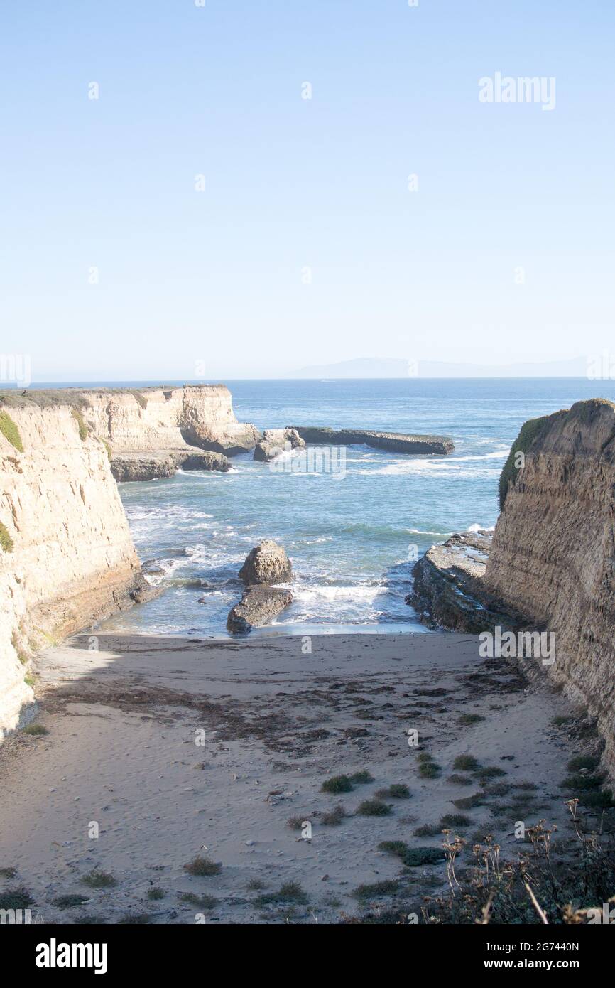 Small narrow box cove surrounded by tall striated cliffs showing effect ...