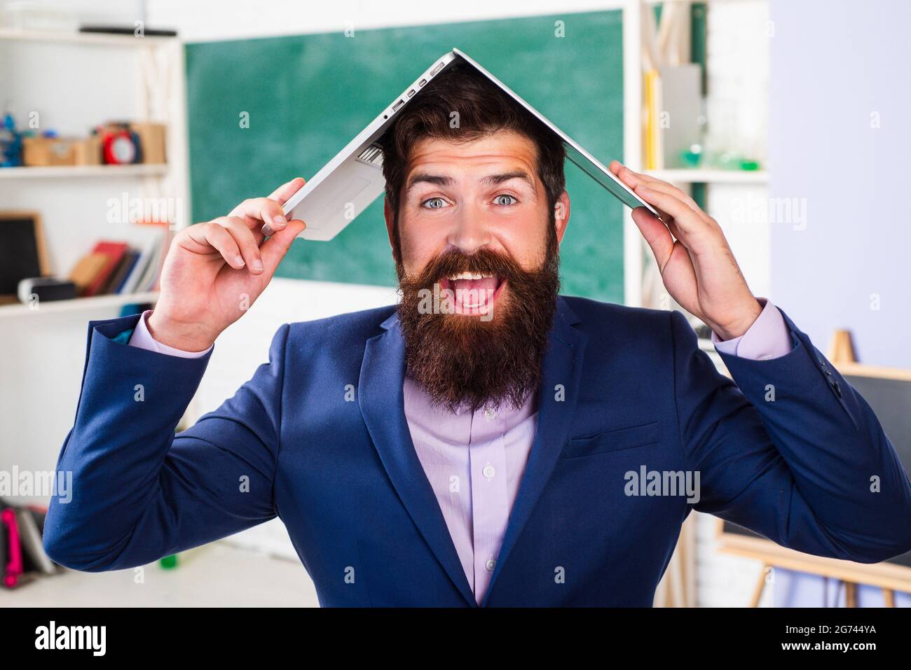 Excited teacher professor with laptop on head wearing formal suit with ...