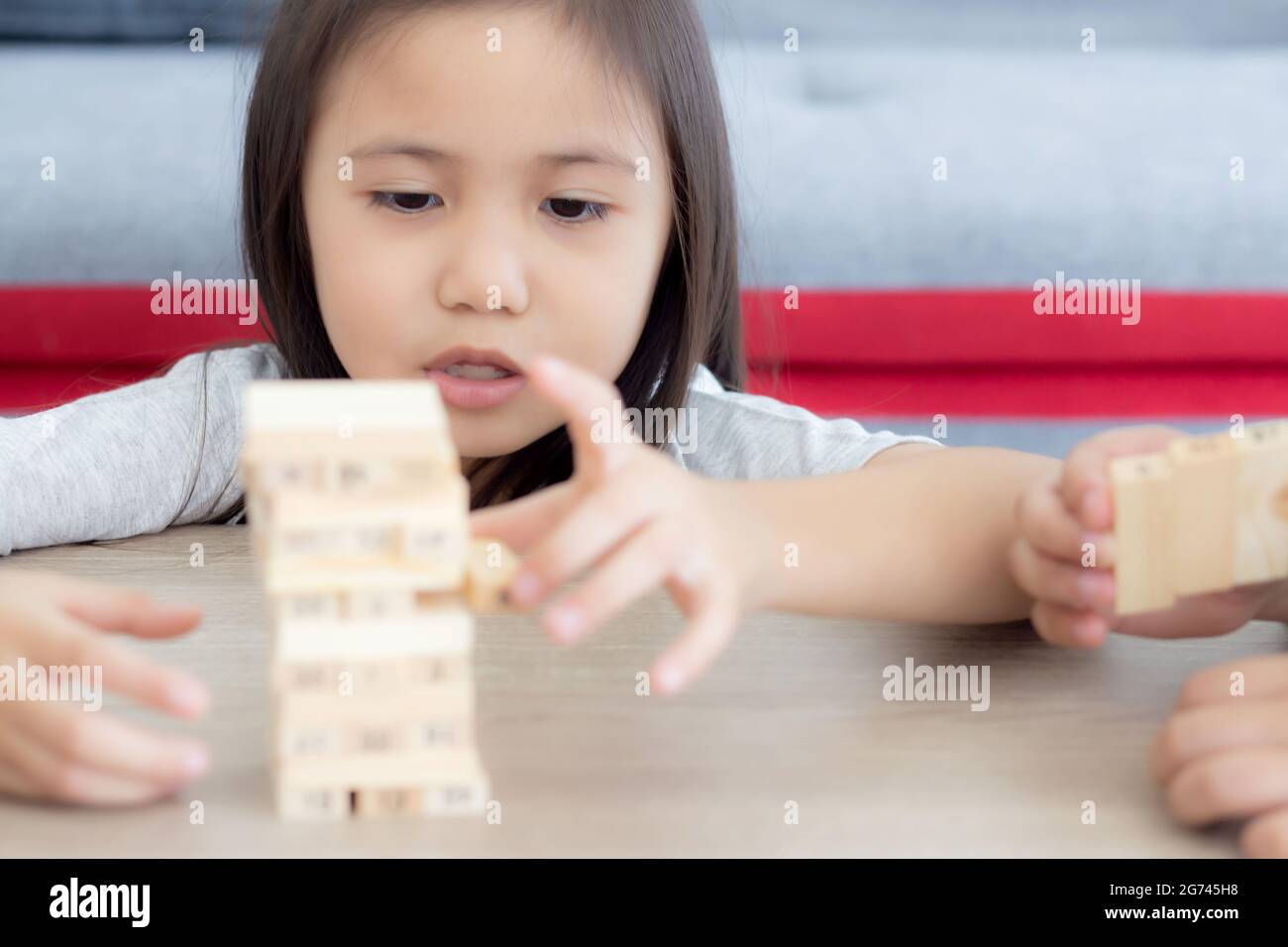 Asian little girl playing game build wood toy with friends on table at ...