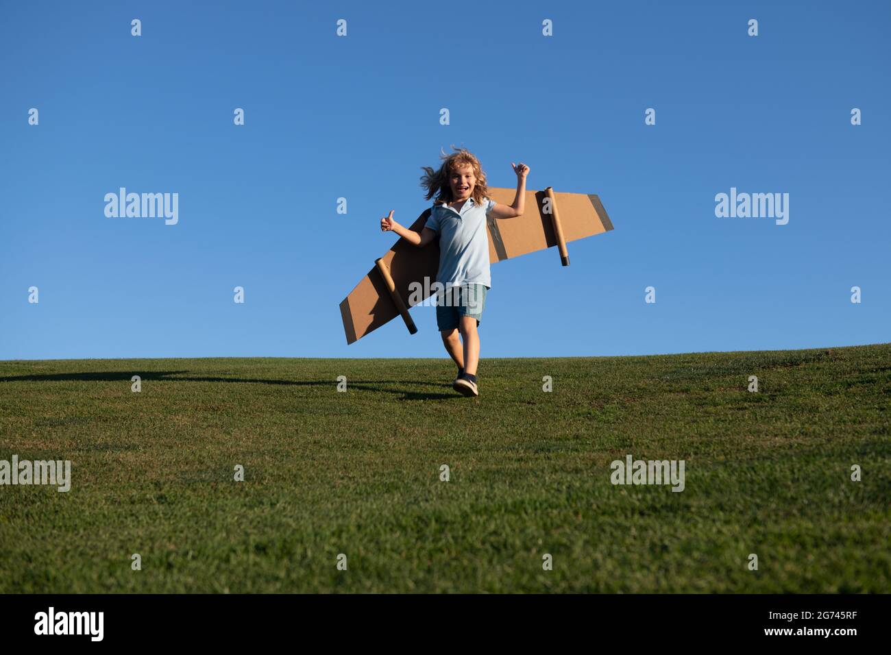 Child boy jumping and running with toy airplane wings. Dream of ...