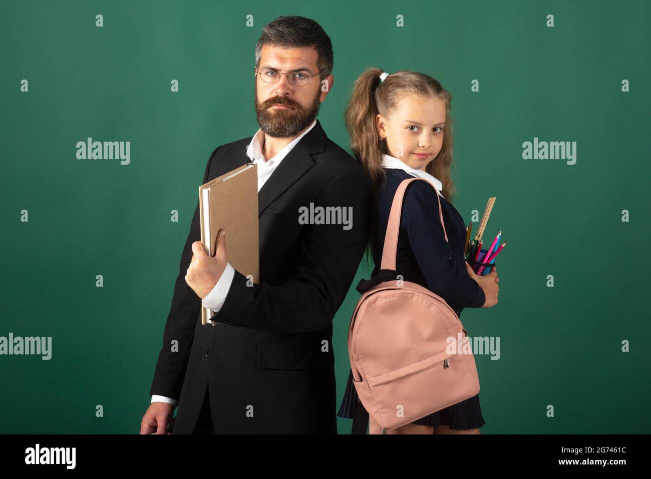 Cute schoolgirl with teacher in school. Studio portrait of tutor and ...