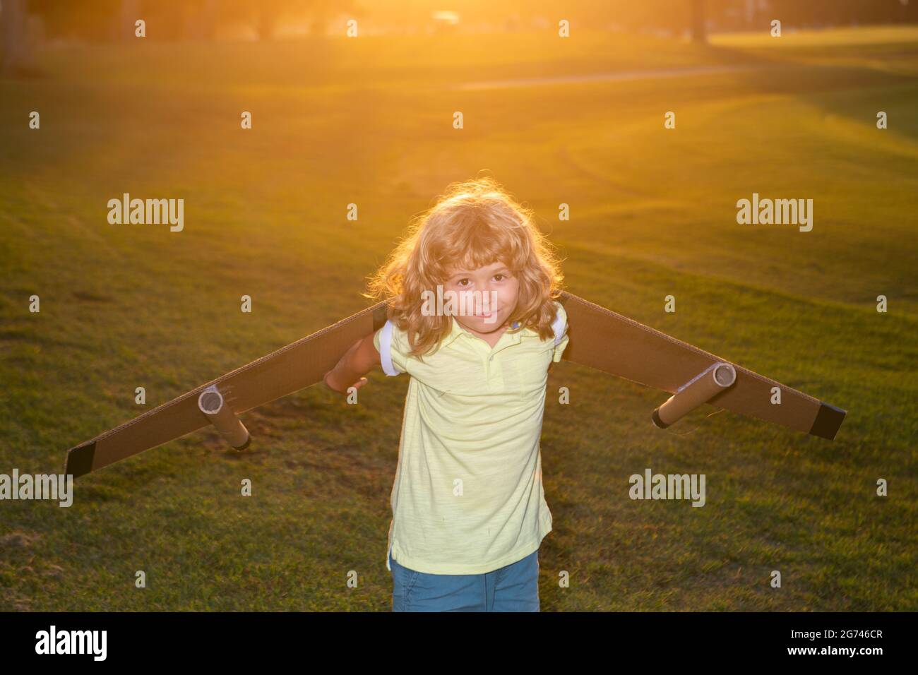 Child playing with toy jetpack at sunset grass field. Child pilot ...