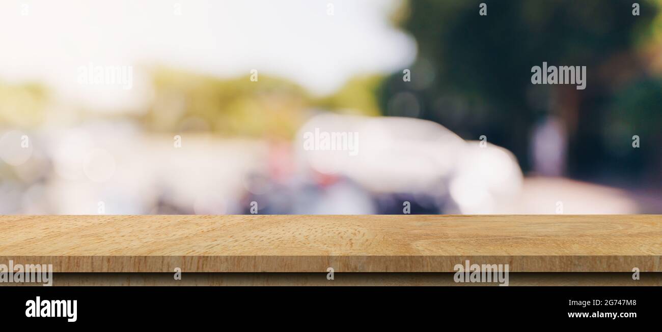 Empty wood table and blurred light table in coffee shop and cafe with ...