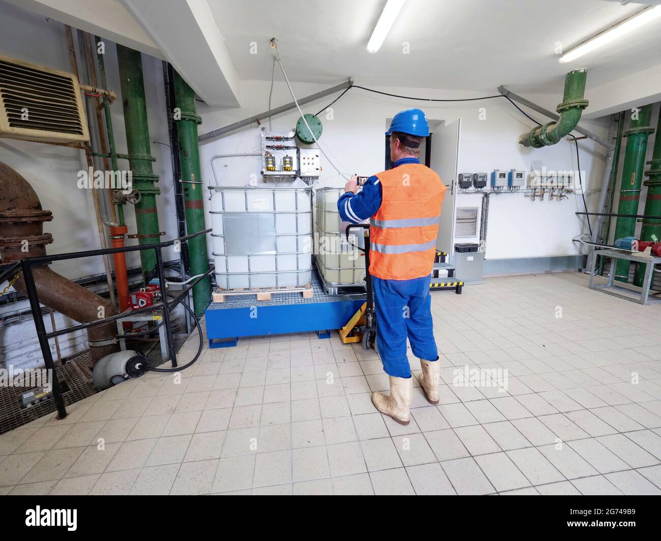 Manipulator in chemical operation wearing reflective vest, blue helmet ...