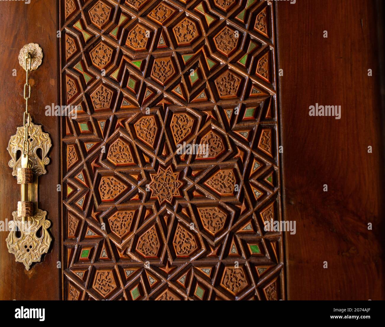 A wooden door with patterns and a gold locker Stock Photo - Alamy