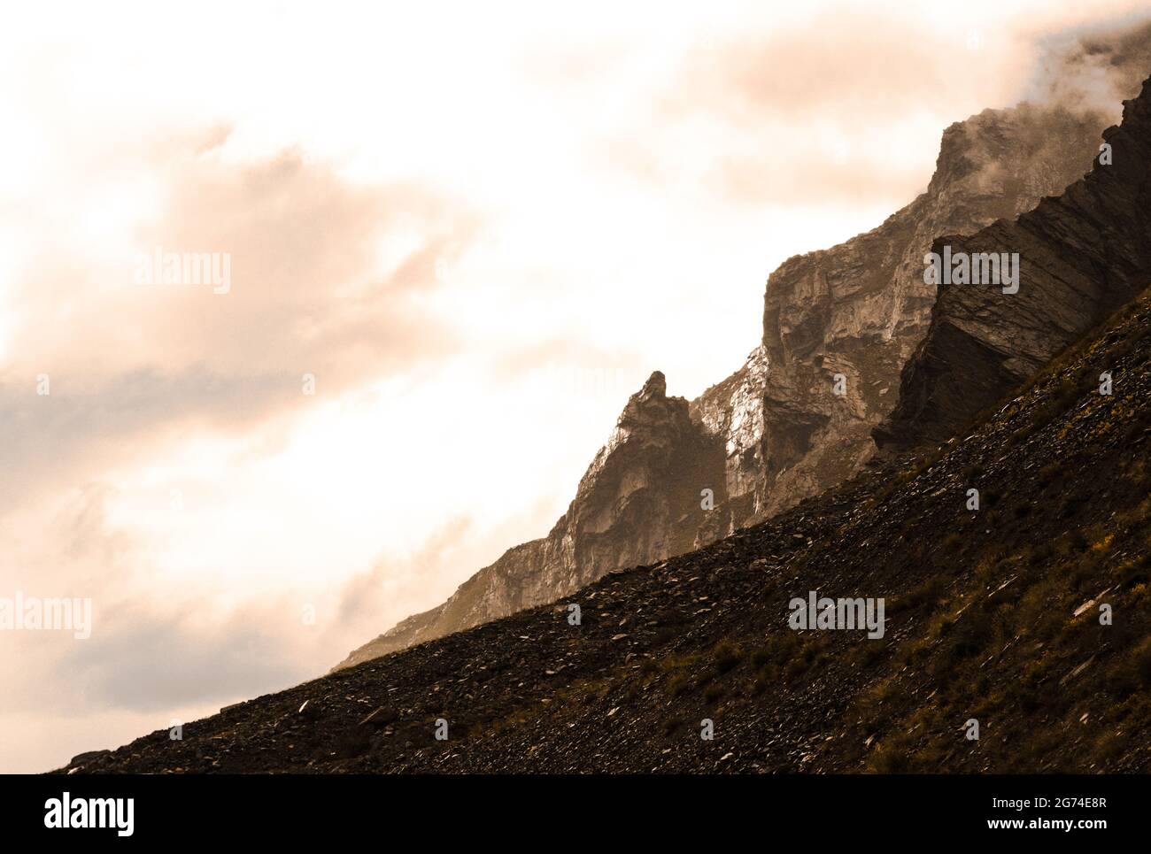 Steep rocky mountain slopes, gleaming in the light of the evening sun ...