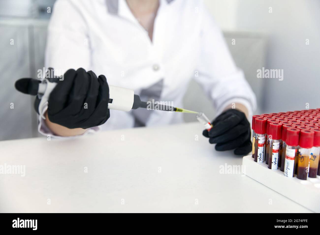 Laboatory worker making blood test holding tube of blood sample for ...