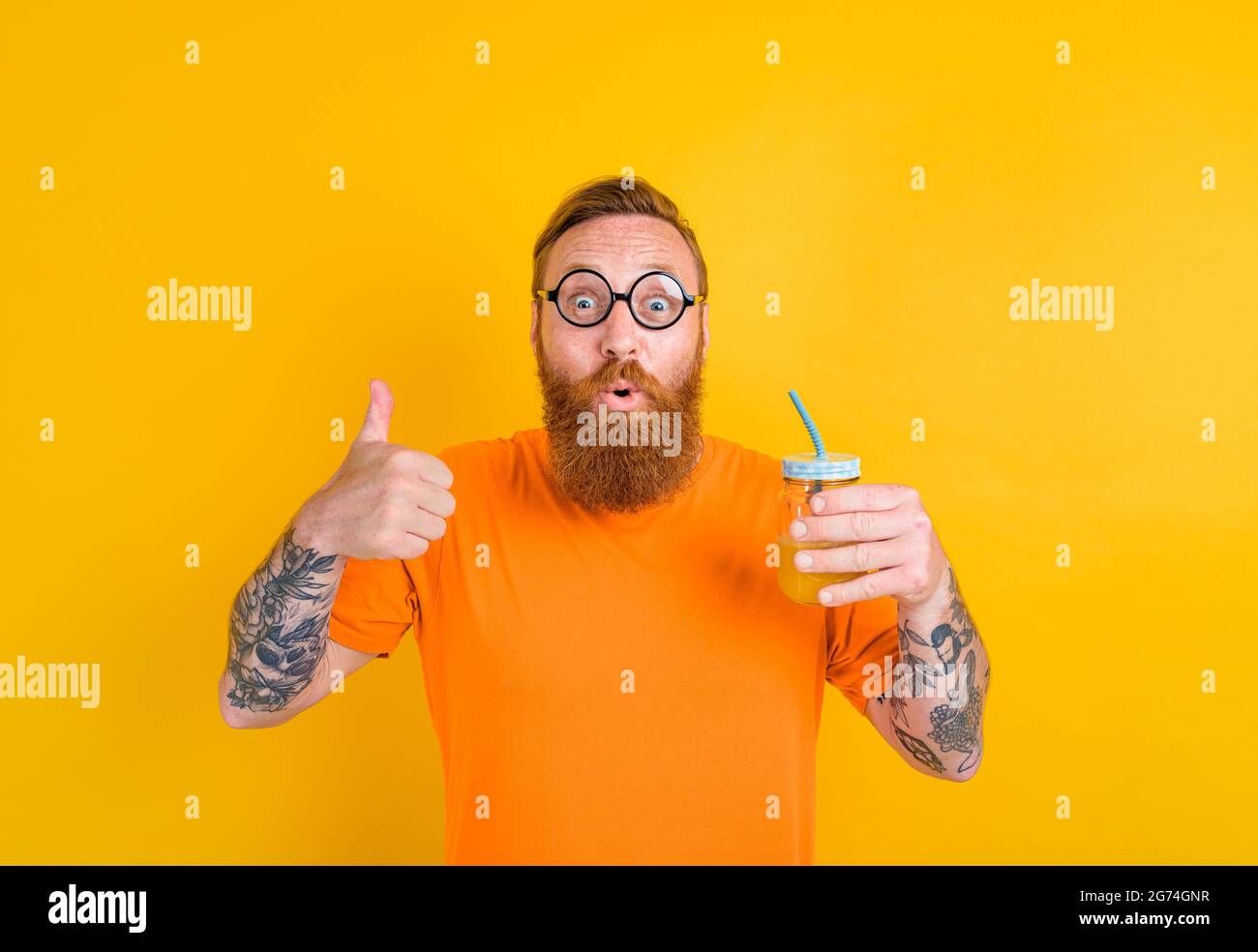 Nerd happy man with glasses drinks a fruit juice Stock Photo - Alamy