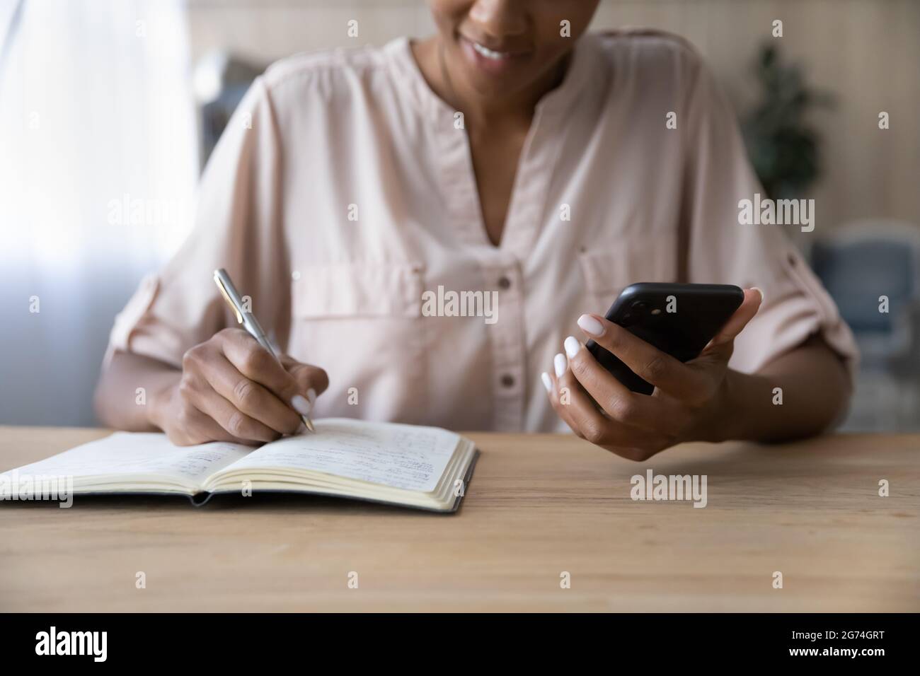 Close up African American woman holding phone, taking notes Stock Photo ...