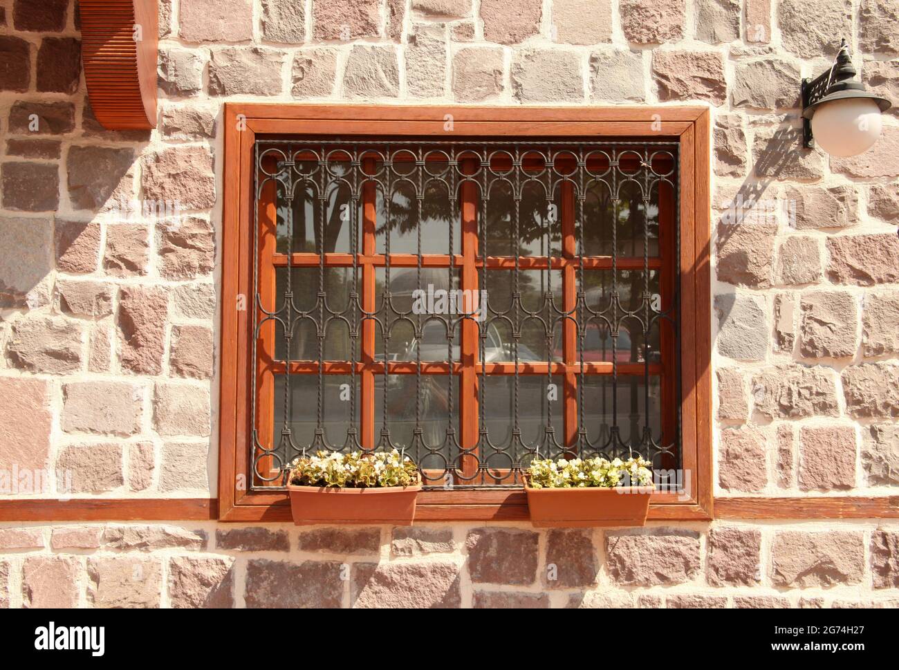 Old stone house. Flowers in the window Stock Photo - Alamy