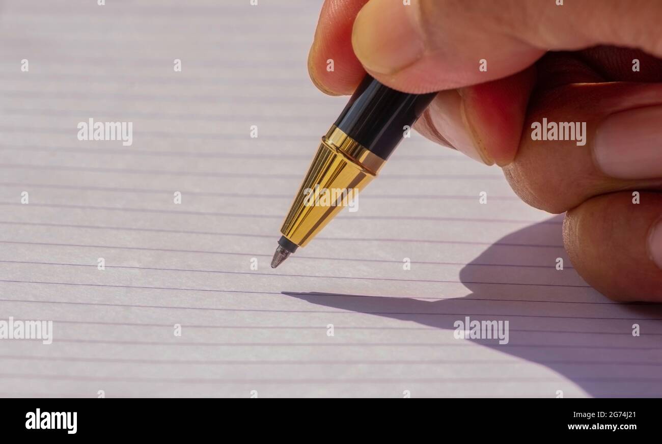 Writing with a gold pen on white paper, selected focus Stock Photo - Alamy