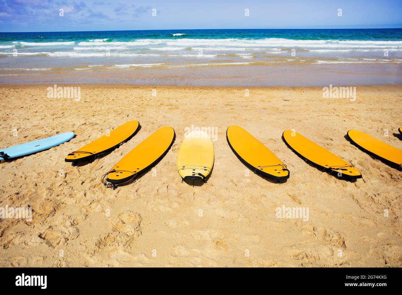 Many surf boards on the beach with sea behind Stock Photo - Alamy