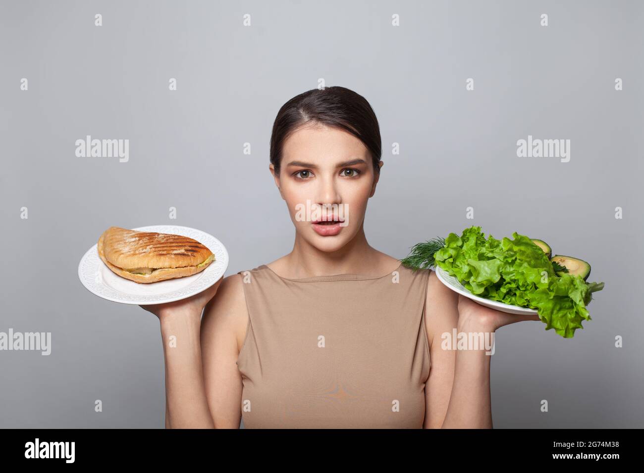 Confused woman trying to decide what to eat, diet concept Stock Photo ...