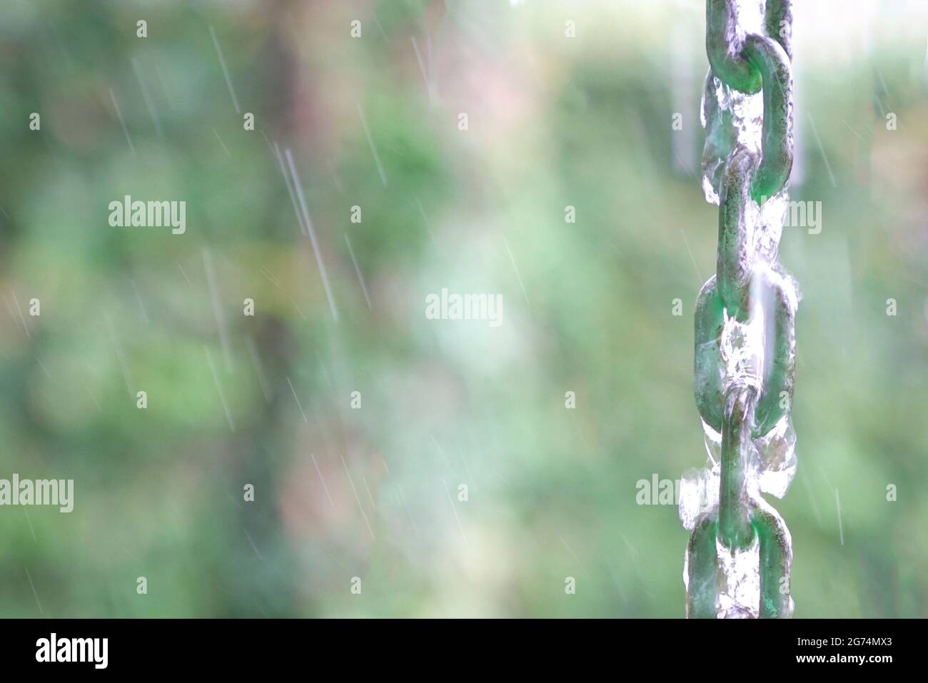 Water dripping and flowing down chain links with raindrops and nature ...