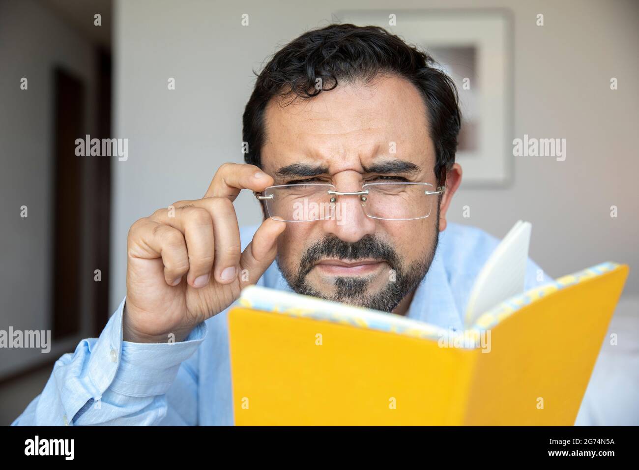middle aged man with poor eyesight trying to read notes Stock Photo - Alamy