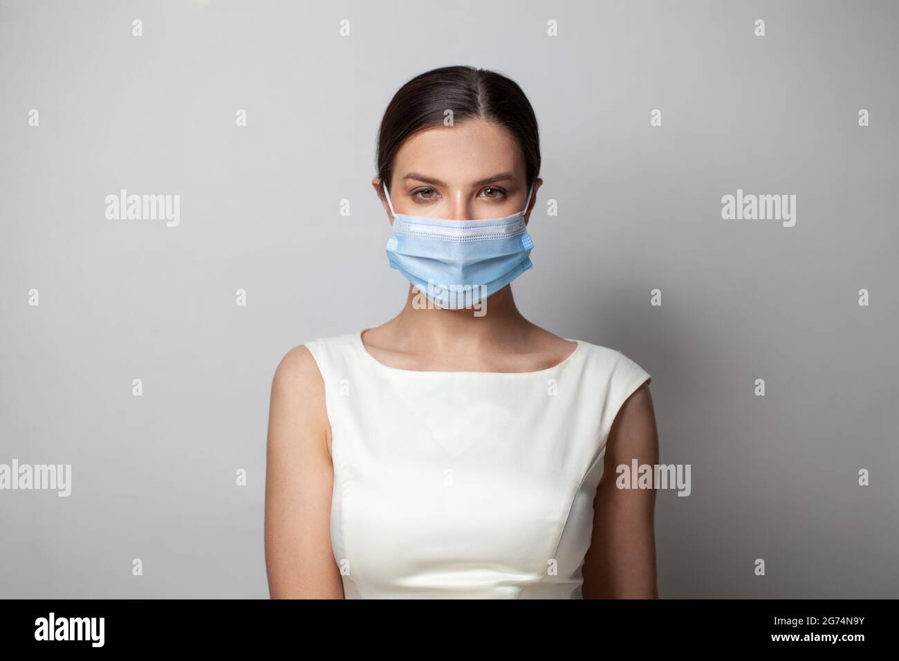 Brunette woman in protection medical mask on white background Stock ...