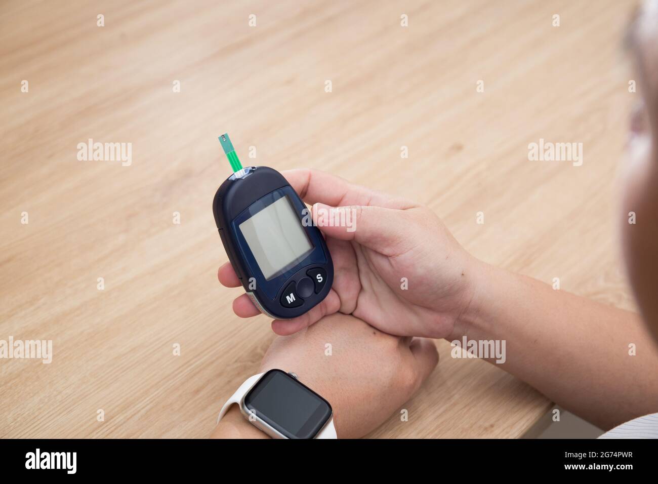 A high angle shot of female hands with glucometer testing blood sugar ...