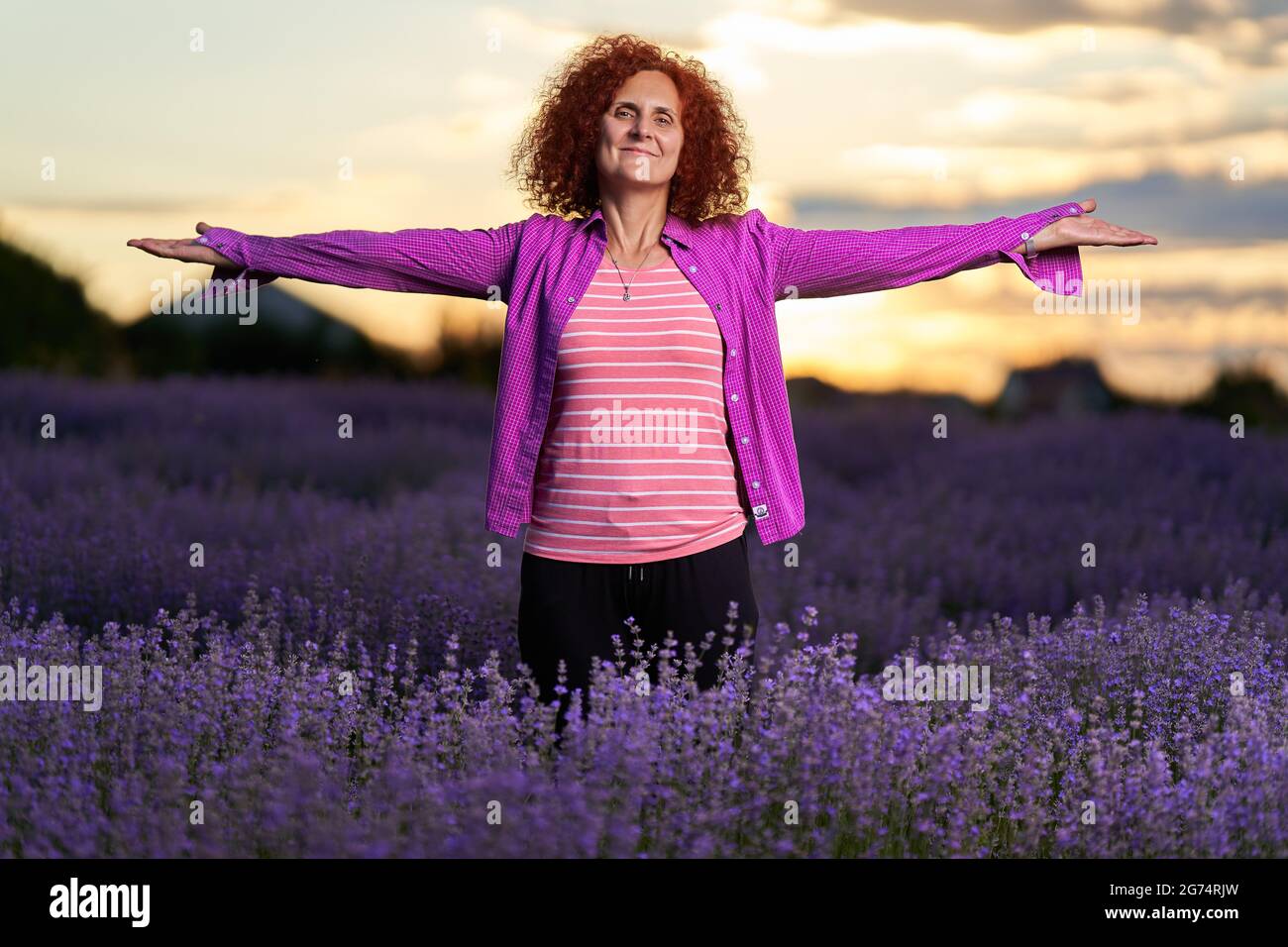 Woman farmer standing in her lavender field at sunset Stock Photo - Alamy